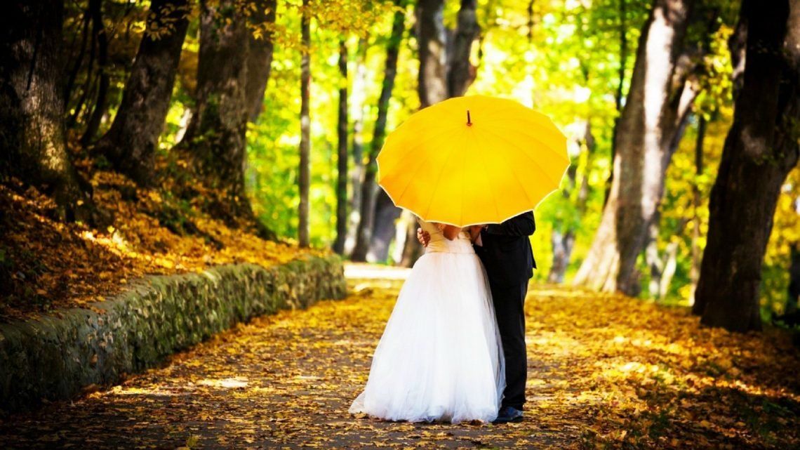 Couple kisses under umbrella couple Aces Ice House